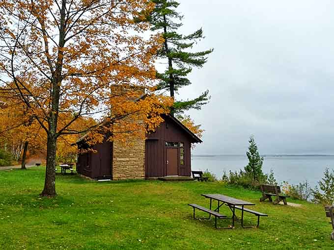 A quiet cabin sits lakeside, looking like the perfect spot for someone who really committed to the "getting away from it all" lifestyle.