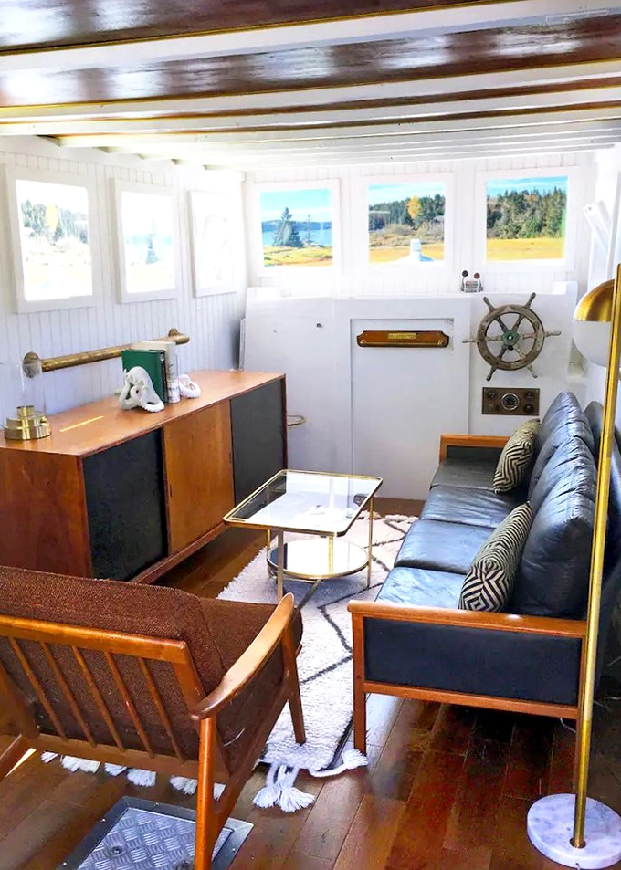 Original maritime elements blend with modern comfort in the boat's lounge, where the captain's wheel stands ready for imaginary voyages.