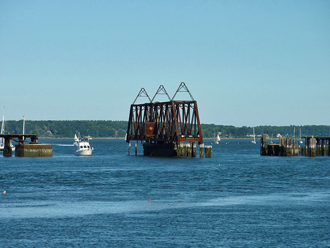 The old bridge structure creates dramatic silhouettes at sunset, transforming from industrial relic to accidental art installation as day turns to dusk.