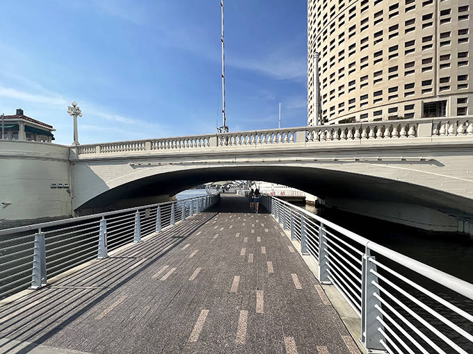 The pathway ducks beneath bridges and emerges on the other side, creating moments of transition that feel like urban adventures.