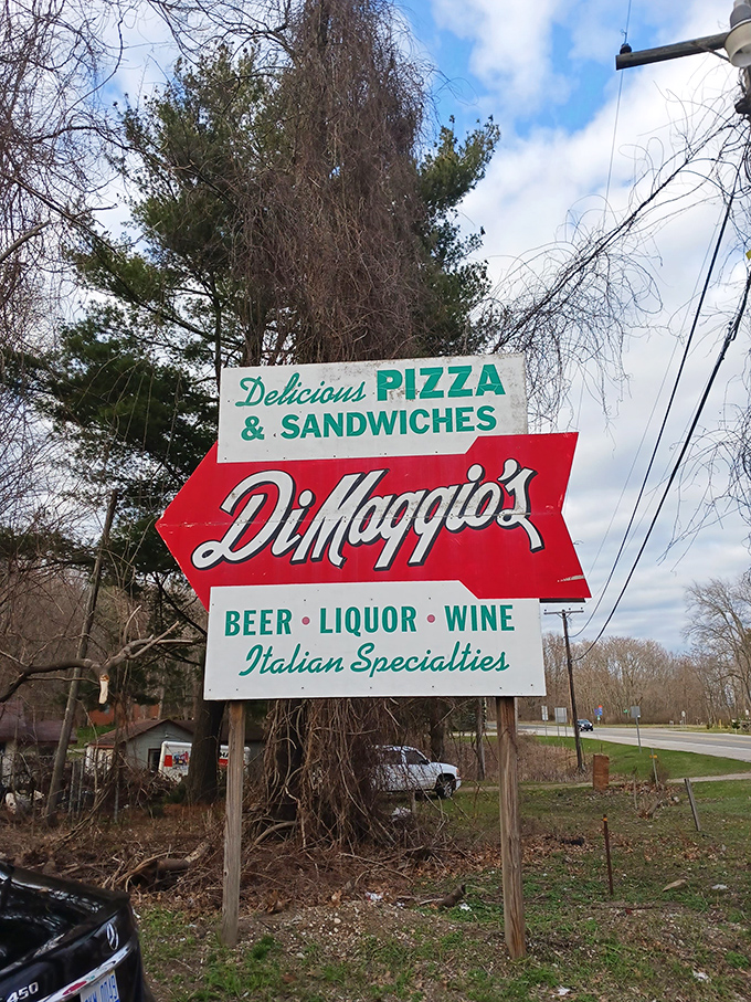 The vintage roadside sign points hungry travelers toward pizza paradise, a colorful arrow guiding generations to this Blue Star Highway landmark.