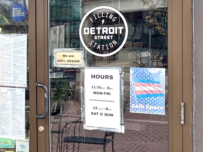 The door proudly announces "100% Vegan!" alongside practical information, serving as both invitation and declaration of the culinary philosophy within.