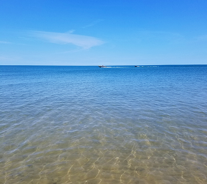 The lake's remarkable clarity reveals a world beneath the surface, where sunlight dances on submerged stones and perhaps glass.