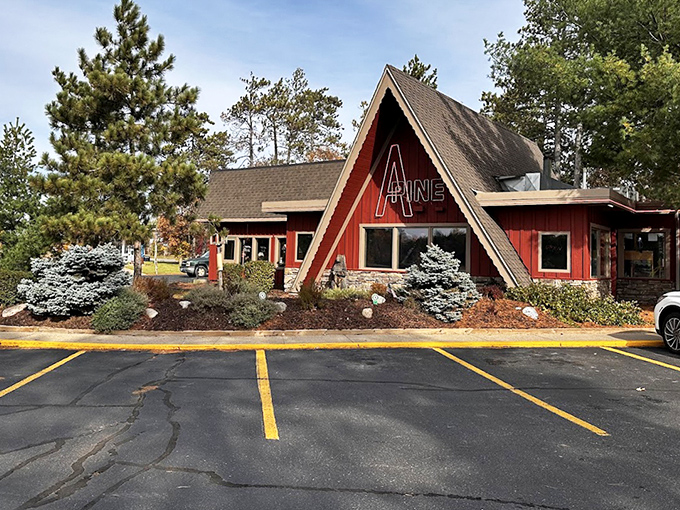 The exterior view showcases thoughtful landscaping with blue spruce and flower beds, softening the transition from Minnesota wilderness to dining room.