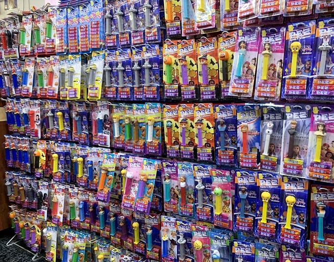 The wall of PEZ dispensers showcases pop culture history through candy delivery systems, with colorful character heads standing at attention like a sweet army.