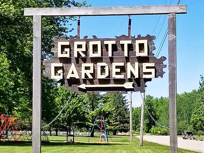 The weathered wooden sign announces your arrival at a place where ordinary expectations should be left behind at the entrance.