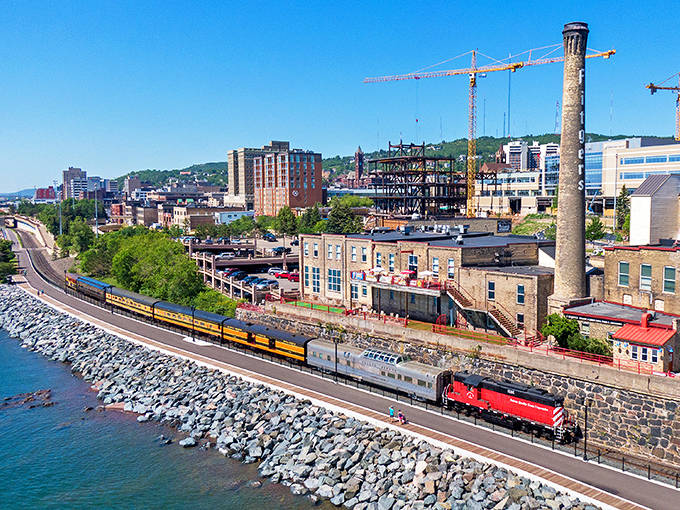 The colorful train snakes along Lake Superior's shore, a ribbon of history threading through Duluth's impressive waterfront landscape.