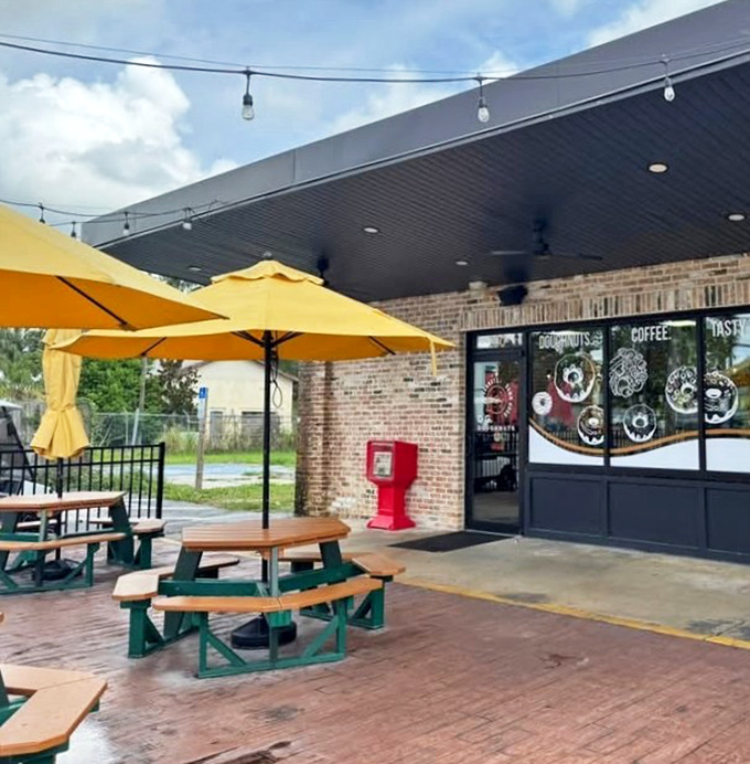Outdoor seating under yellow umbrellas with palm trees overhead captures that perfect Florida morning vibe where calories somehow don't count.