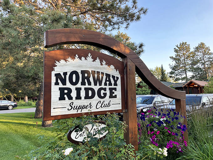The Norway Ridge sign stands proudly among flowers, announcing this culinary destination to lucky travelers who've found their way here.