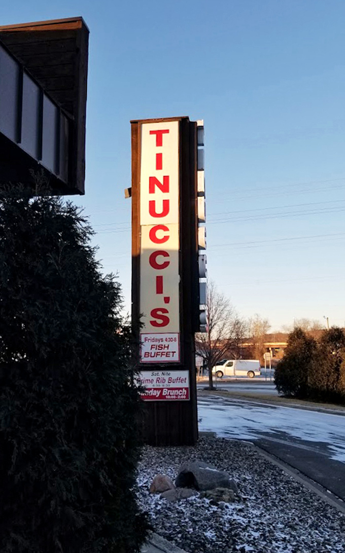The vertical Tinucci's sign stands as a beacon to hungry travelers, advertising their famous fish and prime rib buffets.