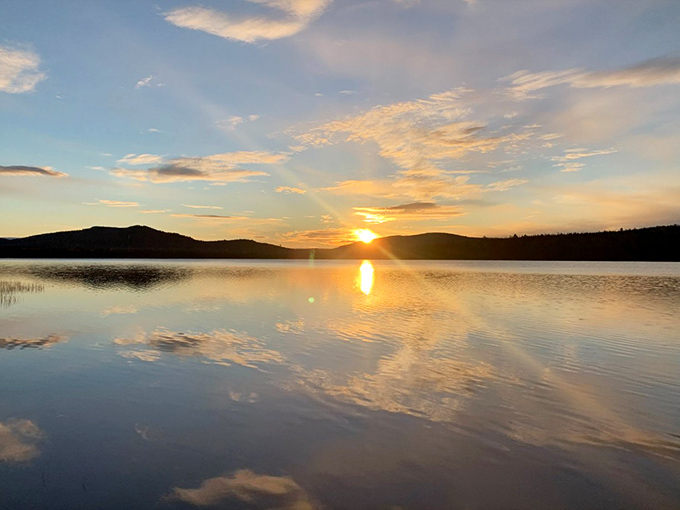 Day's end brings heaven and earth together in perfect reflection, as if the lake borrowed the sky's palette just to double nature's majesty.