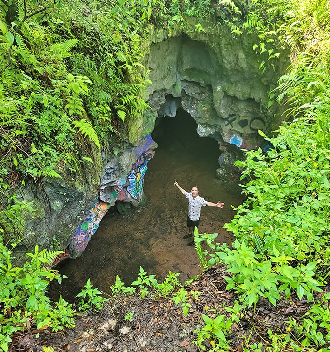 The big reveal: Standing at the cave mouth, this explorer celebrates the thrill of discovery in Florida's hidden underworld.