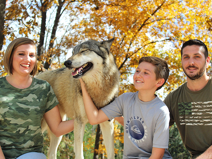 A happy family moment with a magnificent wolf at Seacrest Wolf Preserve, where wild meets wonderful in the heart of Florida's panhandle.