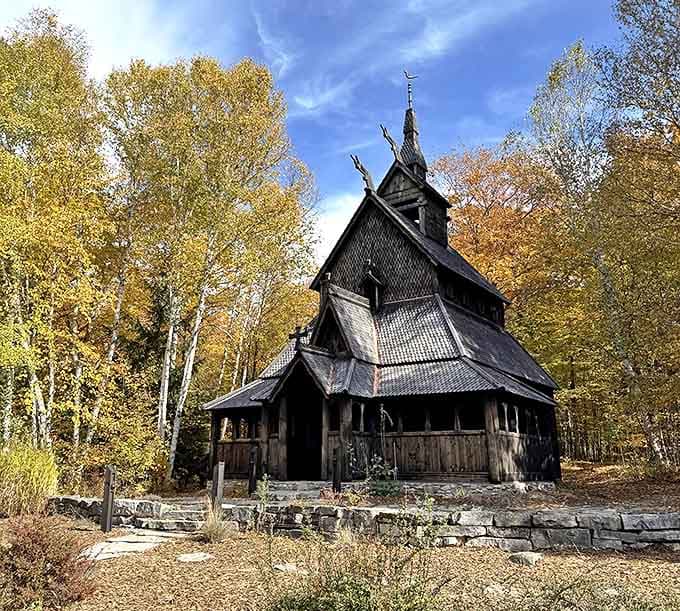 Ancient wooden dragons guard this Norwegian church, standing sentinel among autumn-painted birch trees like a portal to Viking legends.