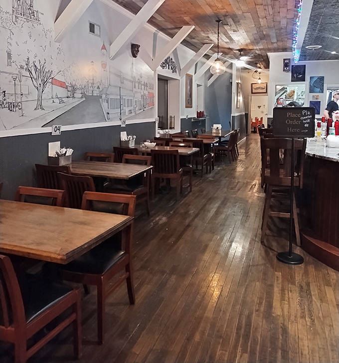 Interior: Warm wooden floors and exposed beams create a space that feels like the living room of that cool friend who actually knows how to cook.