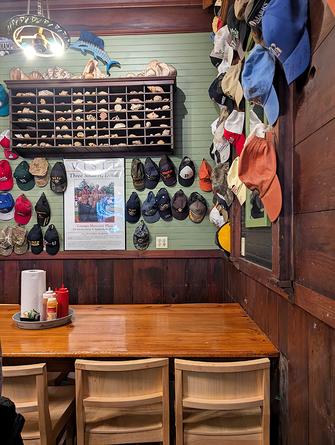 Baseball caps from visitors nationwide create a colorful tapestry against mint-green walls, each hat telling its own story of discovery.