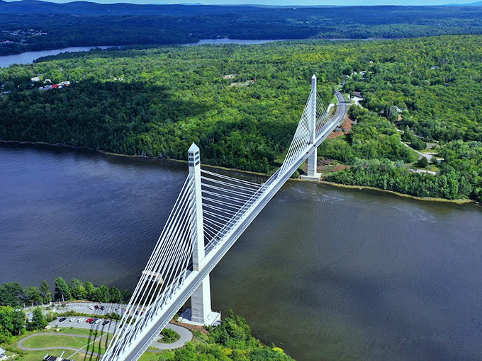 A bird's-eye view reveals the bridge's graceful span across the Penobscot River, connecting mainland Maine to Verona Island through verdant forests.