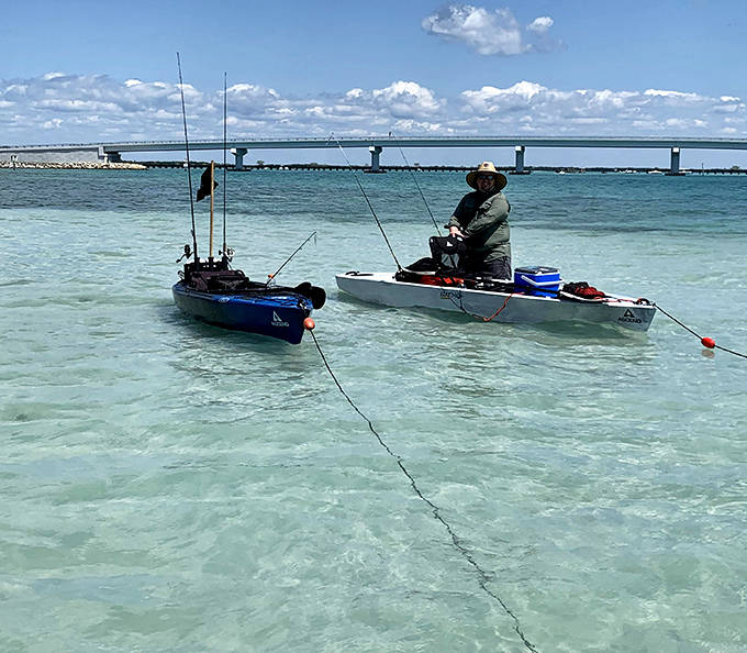 Crystal clear waters reveal nature's swimming pool, where kayakers glide across the surface like colorful water bugs on a perfect day.