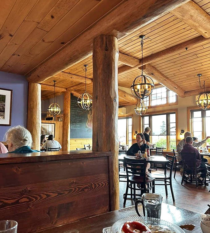 Massive log beams and warm lighting create a cozy North Woods atmosphere where conversations flow as freely as the coffee.