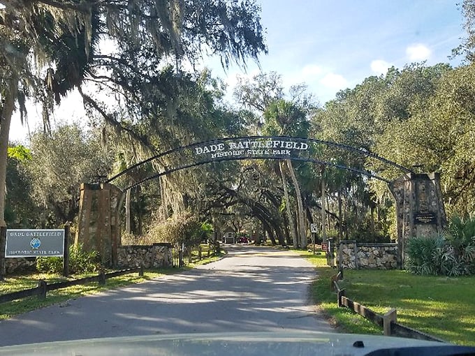 Spanish moss drapes over the historic entrance to Dade Battlefield, where history and nature intertwine. The stone archway stands as a timeless portal to Florida's past.