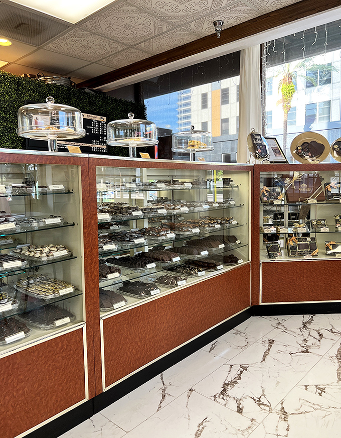 Schakolad's elegant display cases showcase rows of artisanal chocolates, each one decorated with colorful designs that make choosing just one nearly impossible.