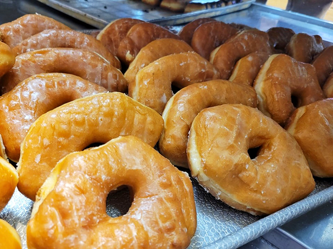 Golden-brown donuts glisten under the display lights, each one hand-crafted and promising that perfect first bite.
