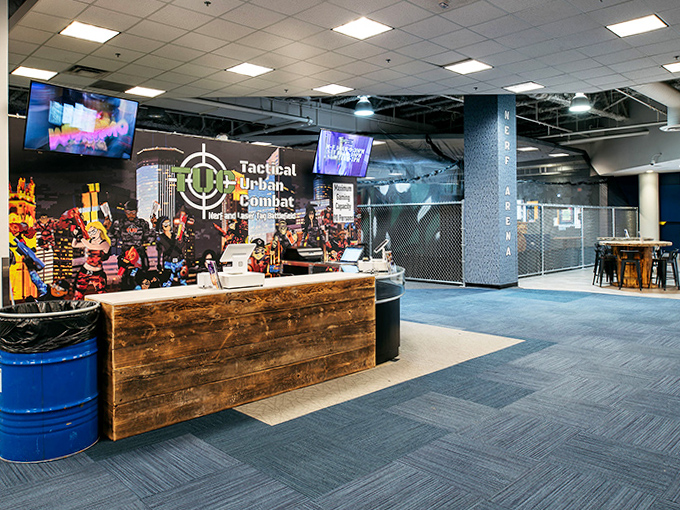 The rustic-industrial reception desk welcomes warriors of all ages with a blend of wooden warmth and tactical cool.
