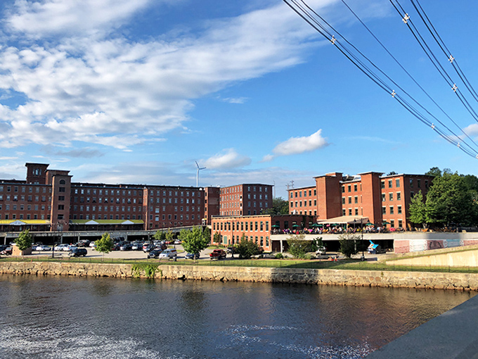 Historic mill buildings standing sentinel along the riverbank &ndash; industrial heritage transformed into charming waterfront attractions.