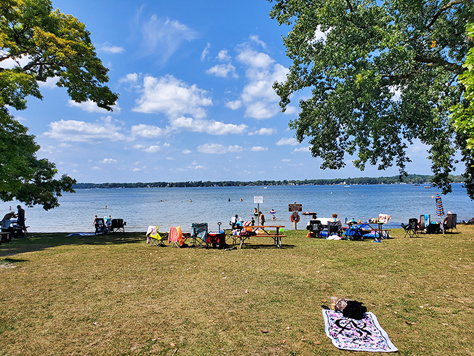 Families claim their spots along the shoreline, where laughter mingles with gentle waves and picnic baskets overflow with summer delights.