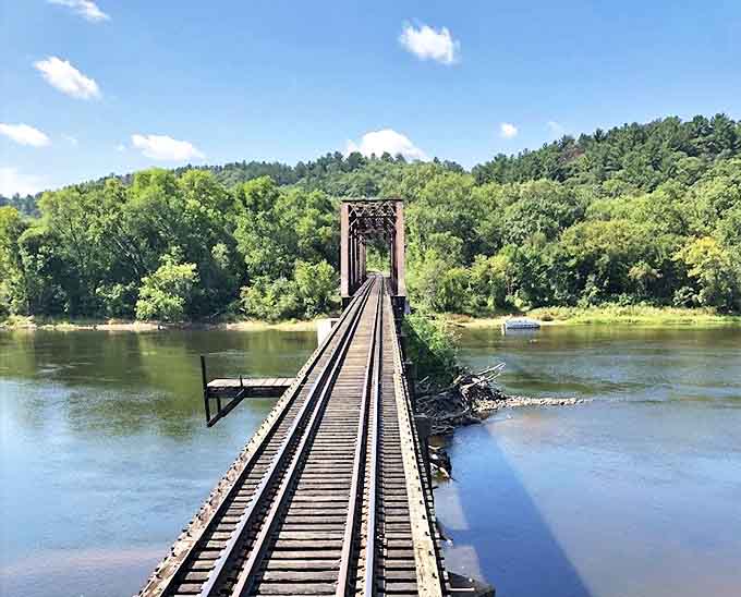 Engineering marvel meets natural wonder as tracks stretch across the St. Croix River, connecting Wisconsin and Minnesota in a breathtaking display of early 20th-century ingenuity.