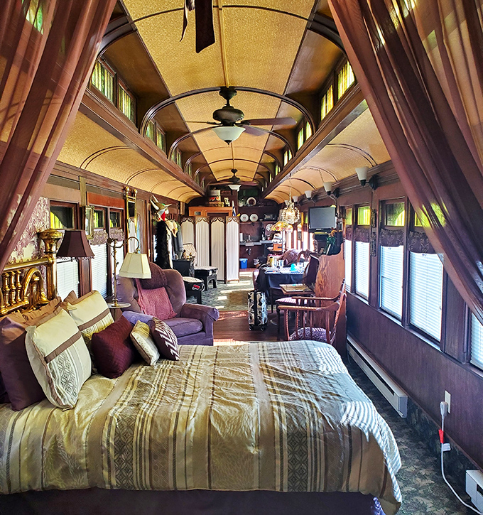 Inside the train car, history meets comfort with warm wood paneling and period details creating a cocoon of nostalgia.
