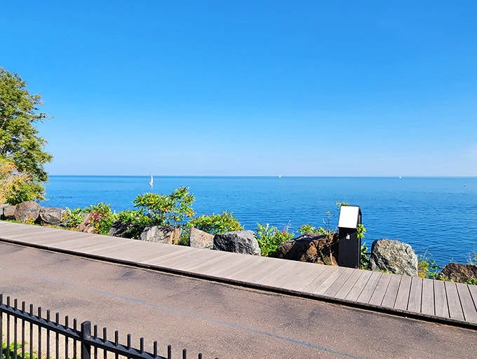 Lake Superior stretches to infinity beyond the boardwalk, its azure waters merging with sky in nature's perfect horizon line.