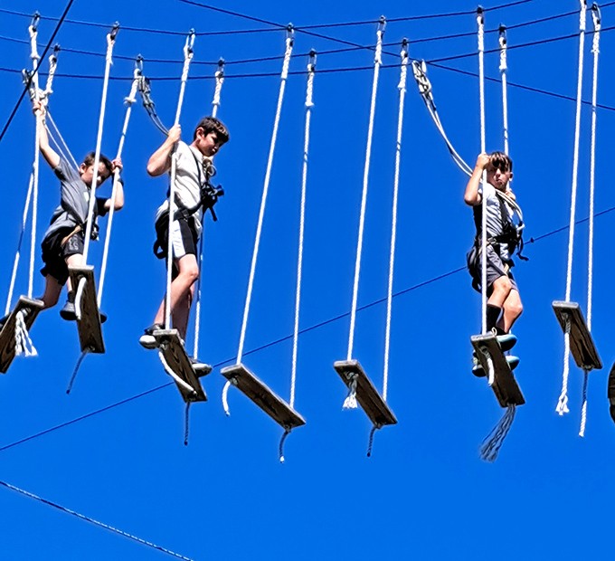 "Just don't look down" is terrible advice when the view is this spectacular. Adventurers test their balance on suspended wooden planks.