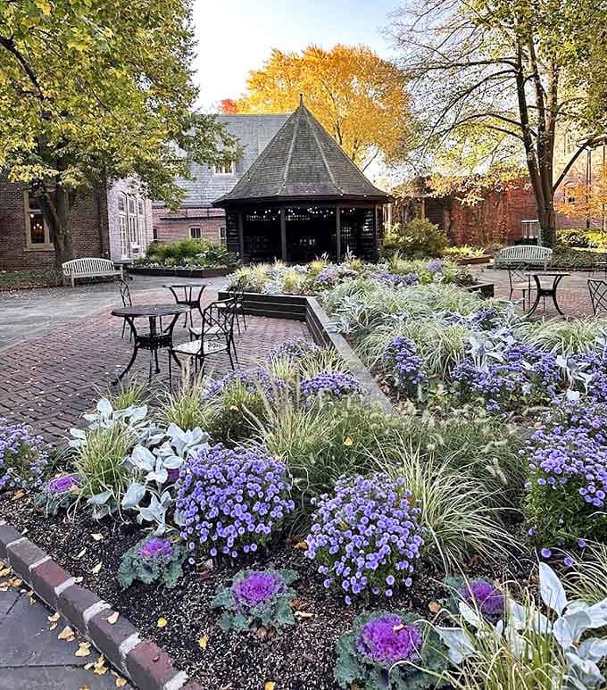A secret garden courtyard invites intimate conversations at The Greenhouse, where brick pathways wind through carefully tended blooms.