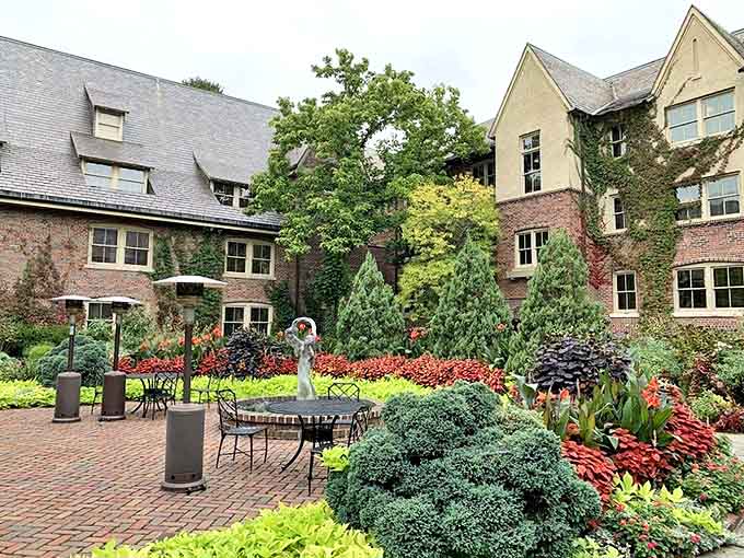 The Greenhouse's elegant courtyard garden bursts with purple blossoms and ornamental grasses, creating a tranquil oasis for afternoon tea.