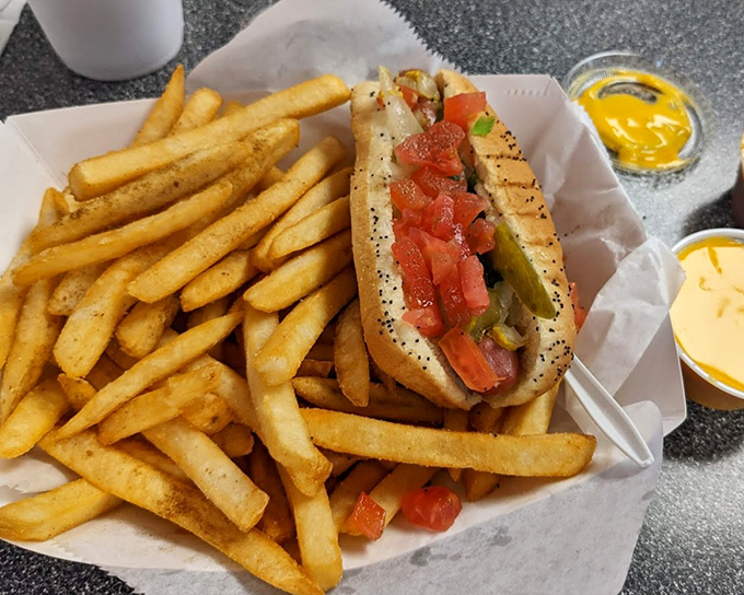 The Chicago-style hot dog in its natural habitat&mdash;nestled among golden fries with that telltale poppy seed bun and garden of toppings that screams "no ketchup needed!"