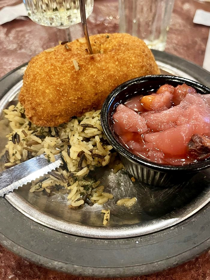 This golden-crusted delight isn't just food; it's edible nostalgia served on a silver platter with wild rice and tangy applesauce.