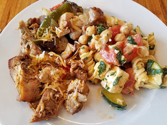 A plate of contrasts: seasoned chicken chunks nestled against colorful pasta salad &ndash; proof that at Q. Cumbers, you're the architect of your perfect meal.