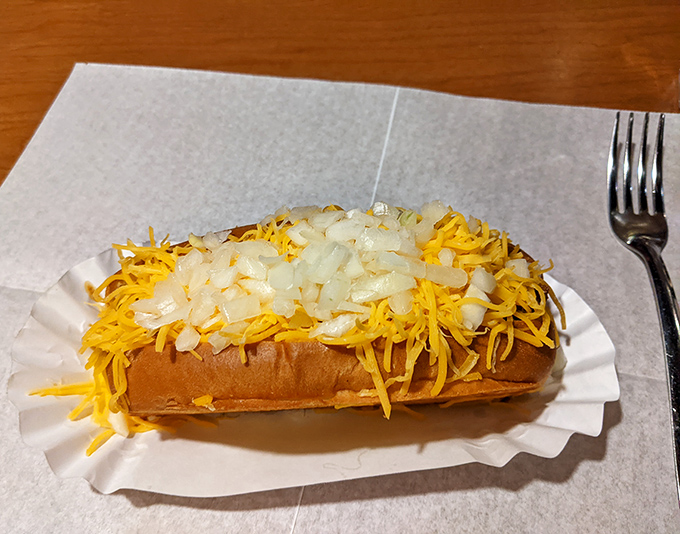 The legendary Coney Dog with cheese &ndash; a symphony of flavors where shredded cheddar melts into savory meat sauce atop a perfectly snappy frank.
