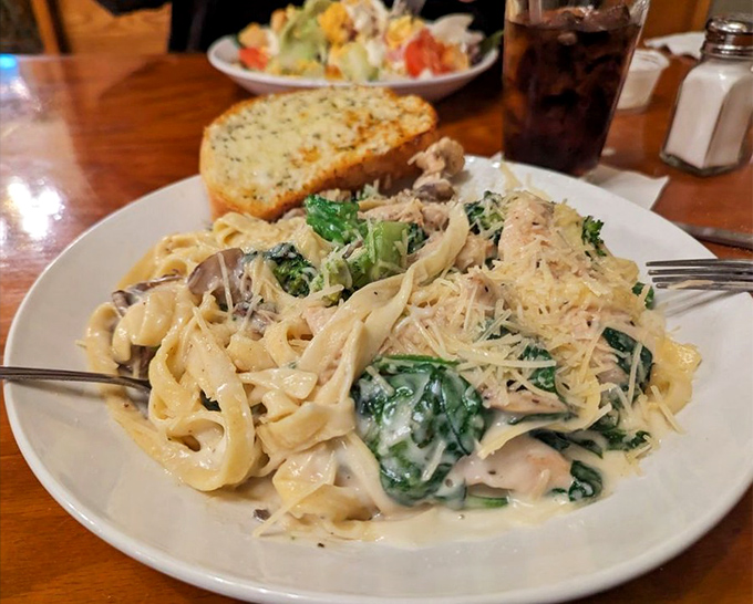 Silky pasta ribbons dance with earthy mushrooms and vibrant spinach in a creamy sauce that somehow manages to be both indulgent and refined.