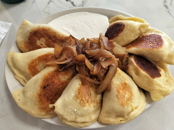 These aren't your average pierogies. Each dumpling is lovingly handcrafted, filled with savory goodness, and topped with caramelized onions that have surrendered all pretense of being vegetables.