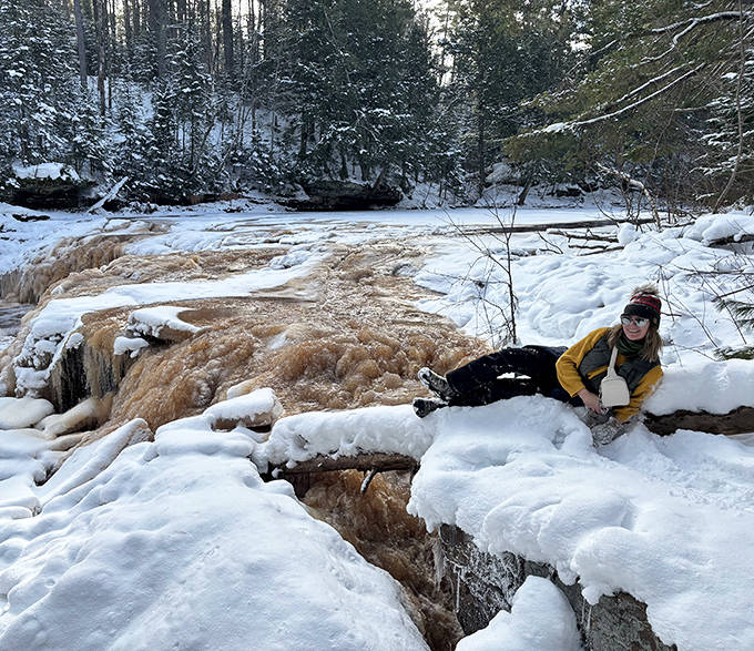 Winter explorers discover the falls' frozen secrets &ndash; bundled against Michigan's chill, this visitor finds the perfect spot for contemplation.