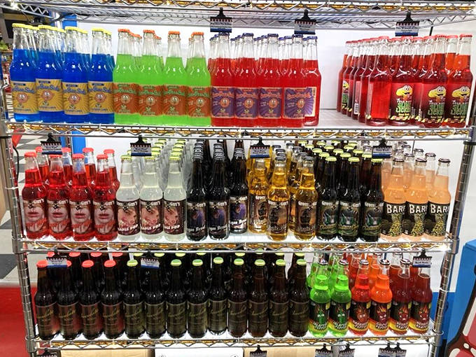A rainbow of glass bottles stands at attention like sugary soldiers, each one containing a different path to carbonated bliss.