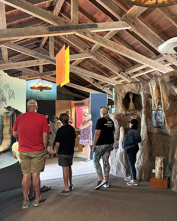 Visitors explore the cave's rustic visitor center, where exposed beams meet exposed bedrock in perfect harmony.