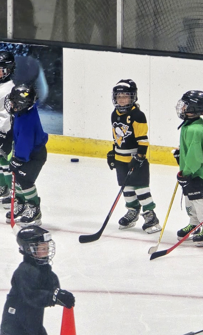 Future hockey stars face off on the ice, their determination visible even through those adorably oversized helmets.
