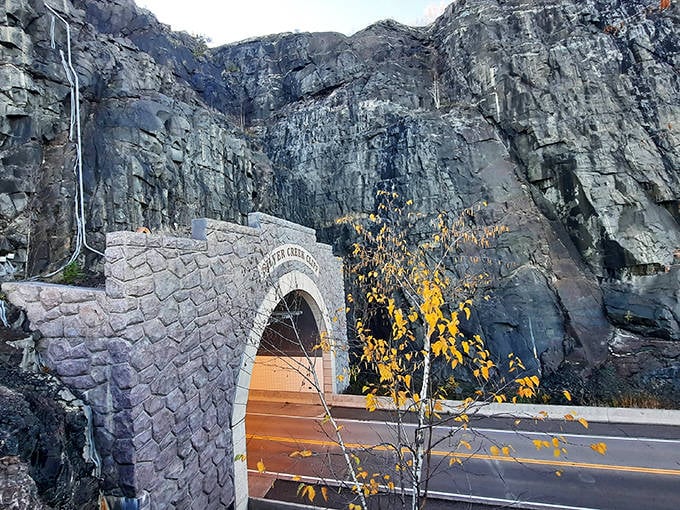 Headlights trace golden paths through the tunnel's curved interior, creating a momentary light show against the tiled walls for each passing vehicle.