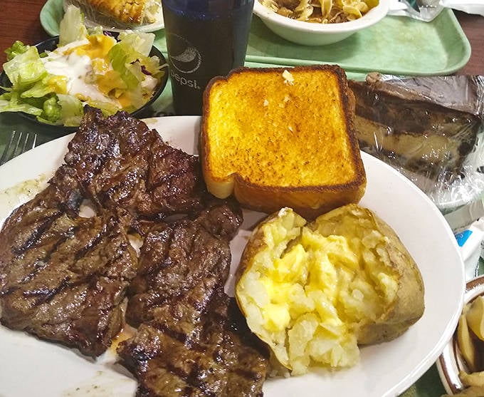 The ribeye arrives like a carnivore's dream come true &ndash; perfectly seared, accompanied by a golden Texas toast and a potato that could feed a small village.