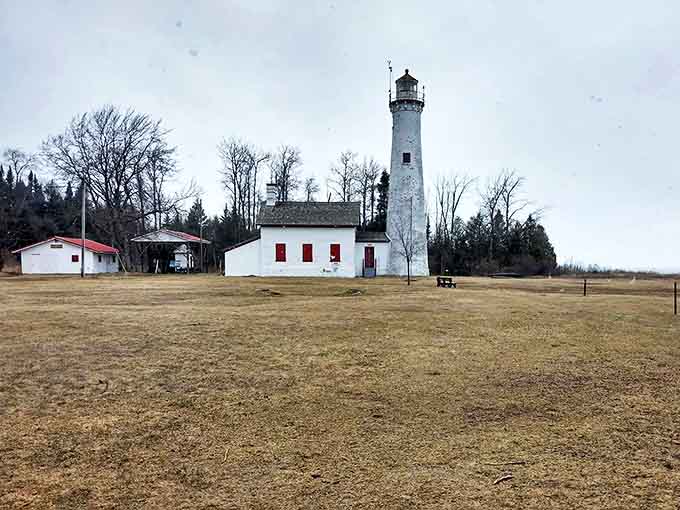 Standing sentinel where land meets water, this charming lighthouse has been guiding sailors home through Great Lakes storms for generations.