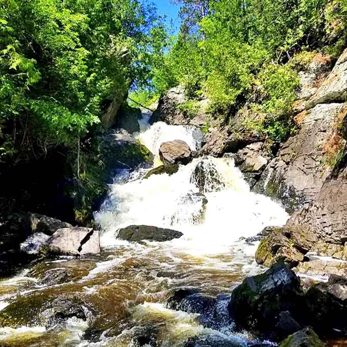 Sunlight catches the spray at Long Slide Falls, sometimes creating rainbows that appear and disappear like magic.