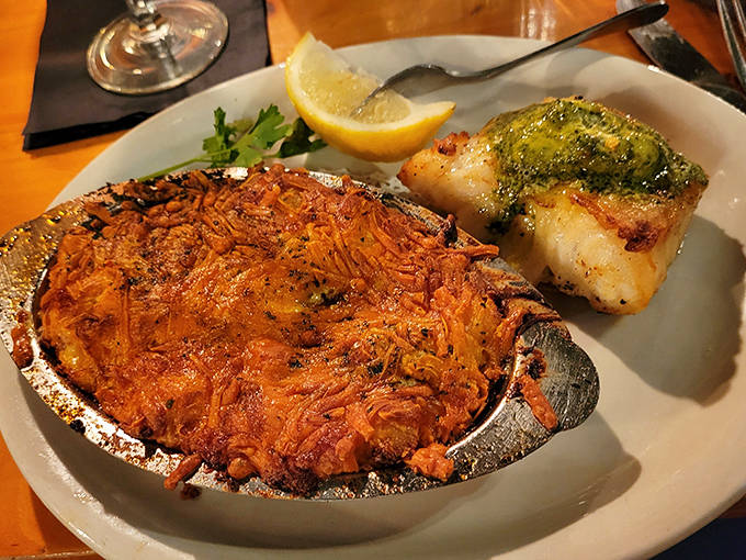 Golden-brown au gratin potatoes bubble with cheese in their individual serving dish, the ultimate comfort food elevated to art form.